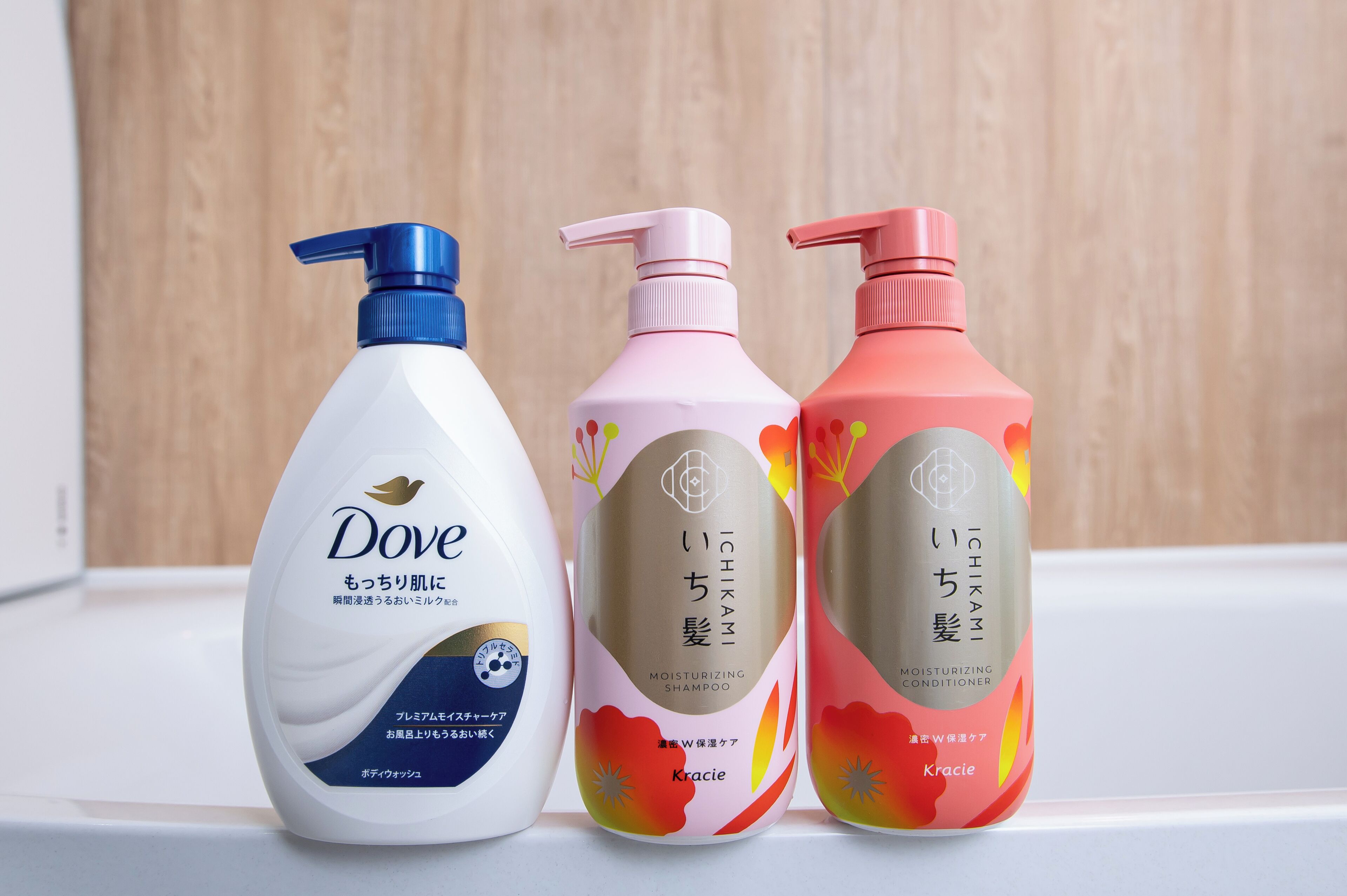 Três frascos de produtos de higiene pessoal Dove, ICHIKAMI e Kracie em uma prateleira.
