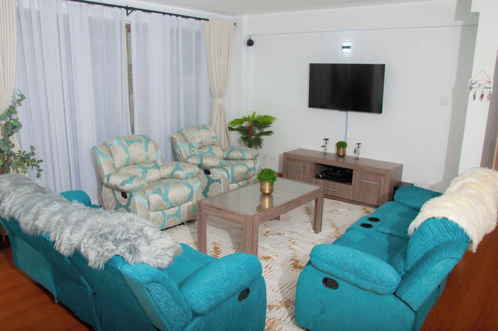 Uma sala de estar com sofá, mesa de centro, televisão e armário.