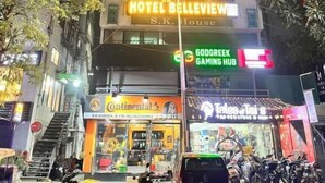 Um edifício de vários andares com uma placa grande que diz 'HOTEL BELLEVUE S.K. HOUSE'.