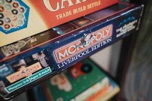 Uma pilha de jogos de tabuleiro, incluindo Monopoly e Settlers of Catan.