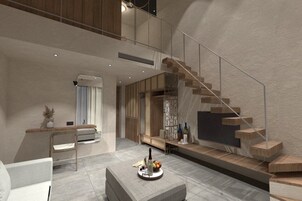 Decoração moderna com escada, área de estar e mesa de jantar com bandeja de frutas.