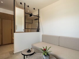 Um interior moderno com um sofá, uma mesa redonda com um vaso e um guarda-roupa.