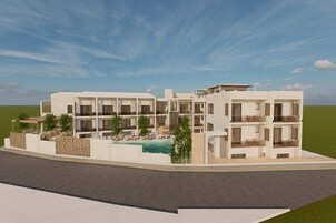 Um hotel moderno de vários andares com piscina e área de estar externa.