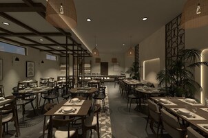 Um restaurante espaçoso com várias mesas e cadeiras, iluminação pendente e design de interiores moderno.
