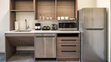 Uma cozinha moderna com eletrodomésticos de aço inoxidável, armários de madeira e máquina de lavar louça embutida.