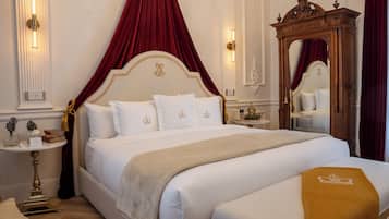 Um quarto bem decorado, com uma cama grande, mesa de cabeceira, espelho e criado-mudo.