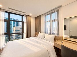Quarto de hotel com uma cama grande, uma escrivaninha e um espelho.