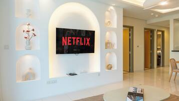 Apartamento luxo, vista para a cidade | Área de estar | Smart TV 65 polegadas com canais digitais