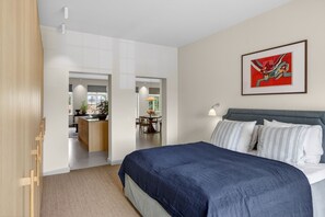 Quarto com uma cama, uma escrivaninha e uma cadeira ao fundo.
