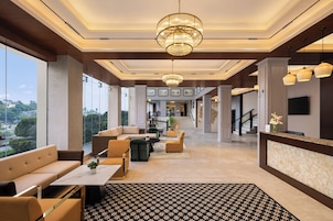 Um hall amplo com teto alto, móveis modernos e vista para a cidade.