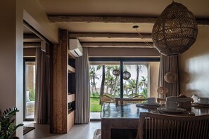 Uma área de refeições com uma janela ampla, móveis de vime e um lustre.