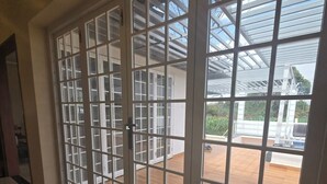 Quarto com uma grande porta de vidro deslizante que dá para uma área externa com deck de madeira.