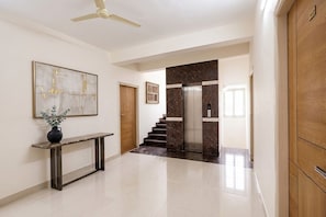 Decoração moderna com escadaria de mármore, ventoinha no teto e design minimalista.