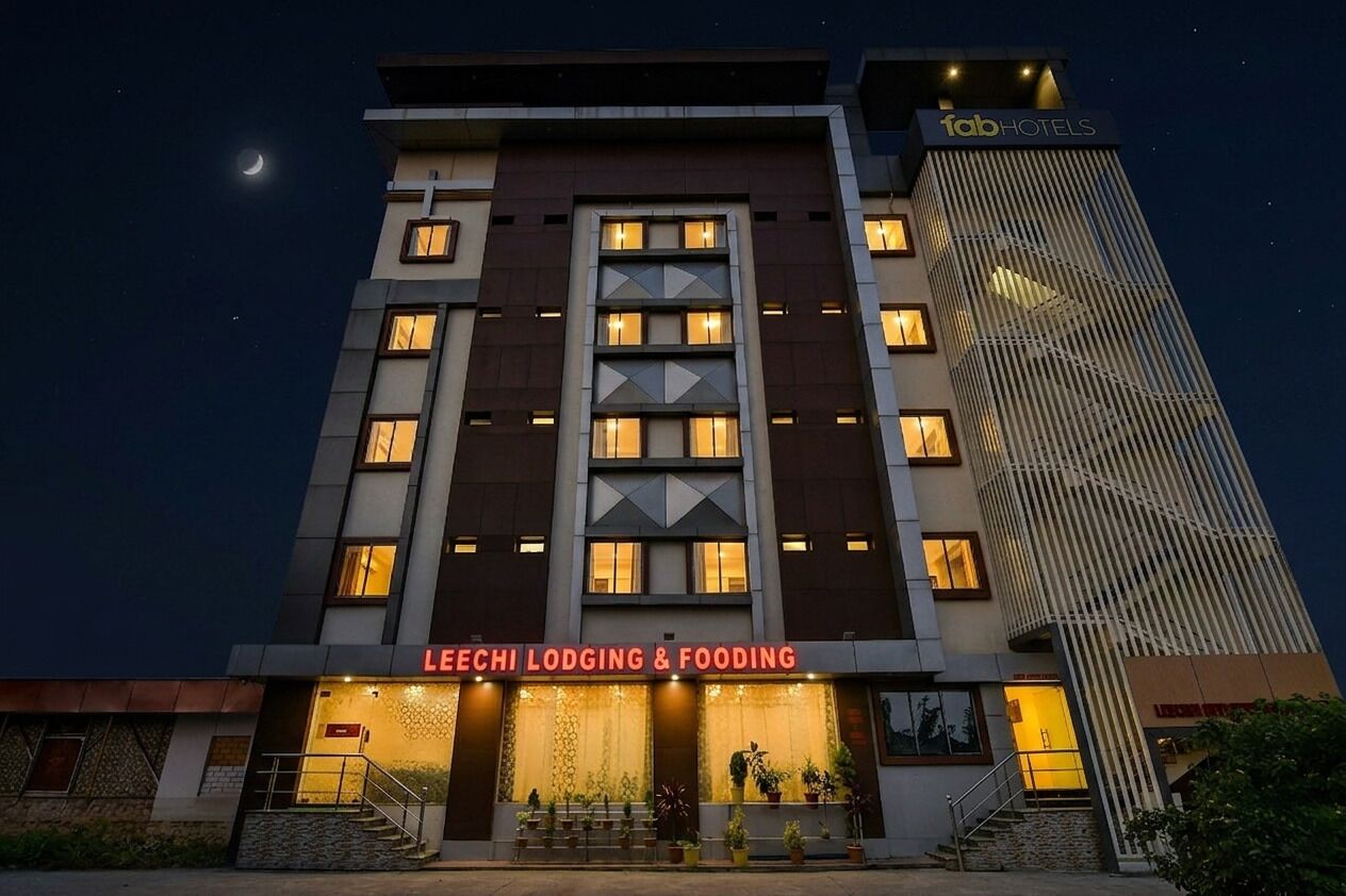 Um edifício de vários andares com uma placa chamativa para 'LEECHI LODGING & FOODING' no nível térreo.