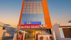 Um edifício moderno de hotel com uma placa grande de 'fabHOTELS', a designação 'Grand' e uma entrada visível.