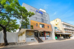 Um hotel com fachada moderna, entrada visível e escadaria que leva à entrada.