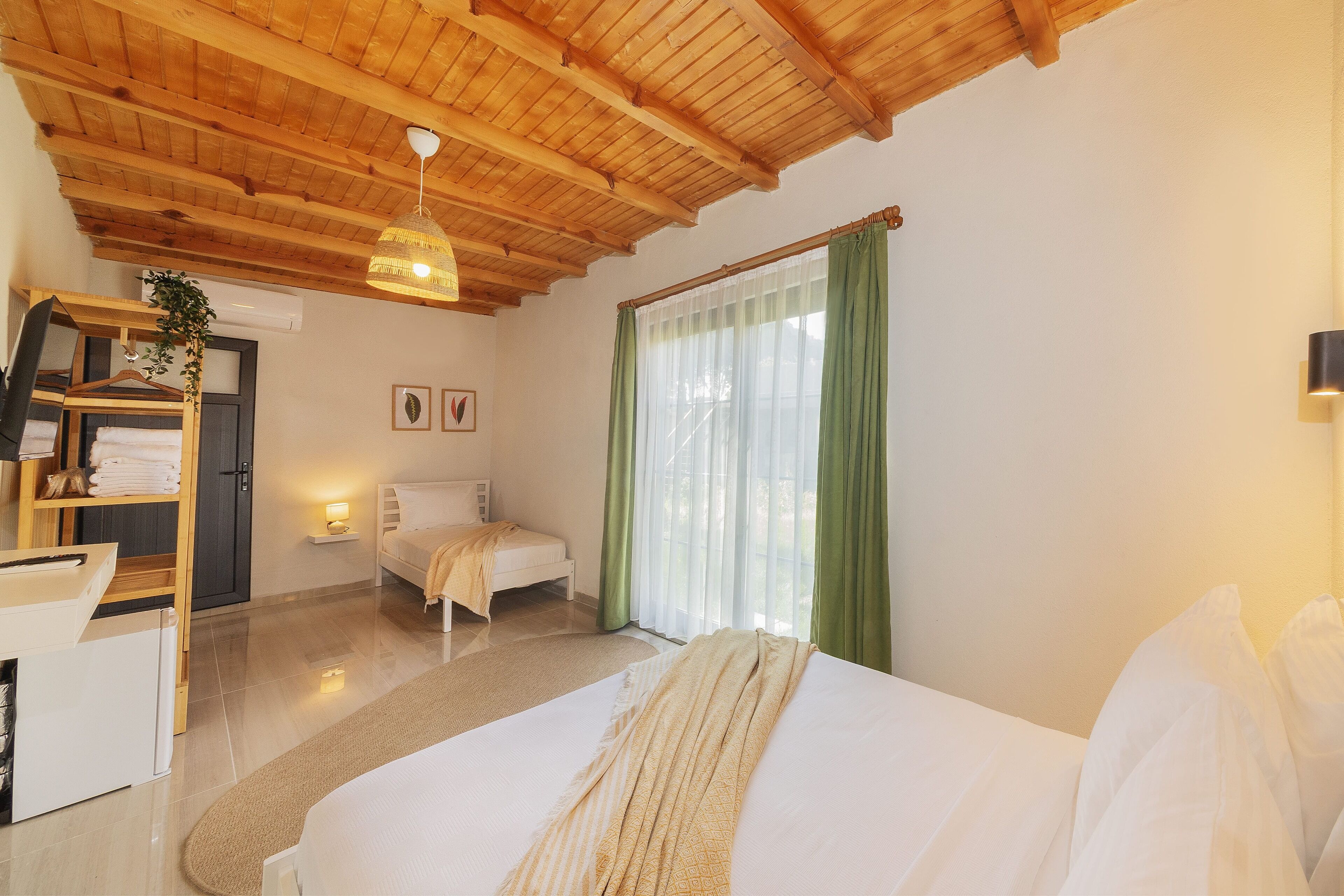Quarto com cama, mesa de cabeceira e planta pendurada.