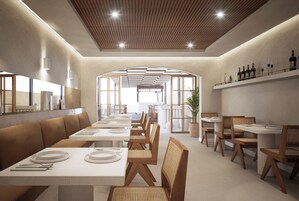 Interior moderno de restaurante com mesas comunitárias grandes, cadeiras de madeira e um arco central.
