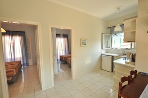 Quarto de hotel com cama, uma kitchenette pequena e banheiro.