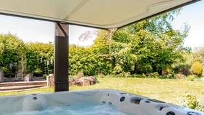 Uma banheira de hidromassagem com vista para um jardim e árvores.