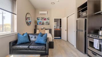Um apartamento moderno com sala de estar, cozinha compacta e quarto.