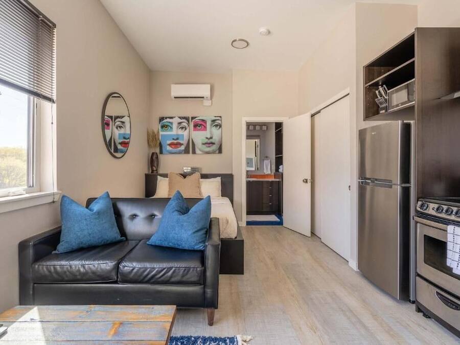 Um apartamento moderno com sala de estar, cozinha compacta e quarto.