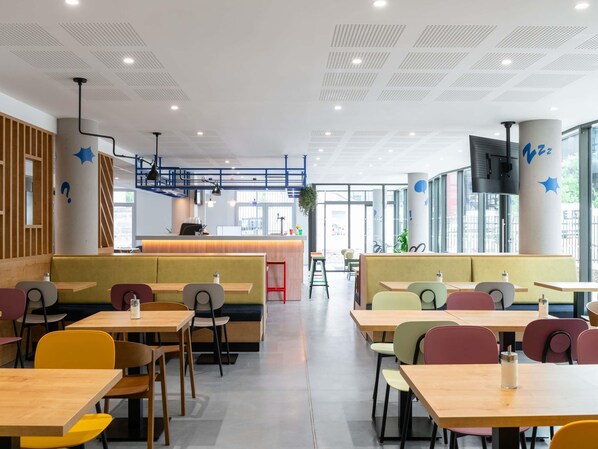 Um restaurante moderno com cabines, mesas e um bar.