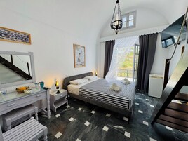 Quarto com cama, mesa de cabeceira, luminária e janela com cortinas.