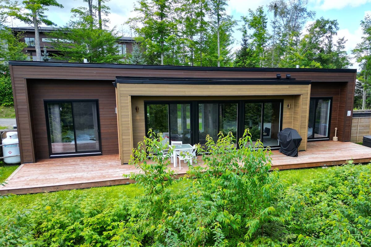 Uma casa moderna com deck, portas de vidro deslizantes e área para churrasco.