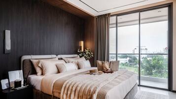 Quarto moderno com uma cama grande, mesa de cabeceira e vista da cidade através de amplas janelas.