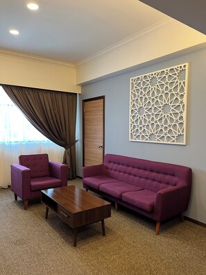 Um quarto com sofá, poltrona e mesa de centro.