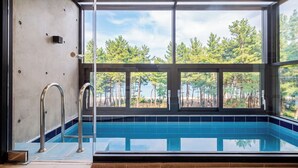 Piscina com vista para árvores e uma praia.