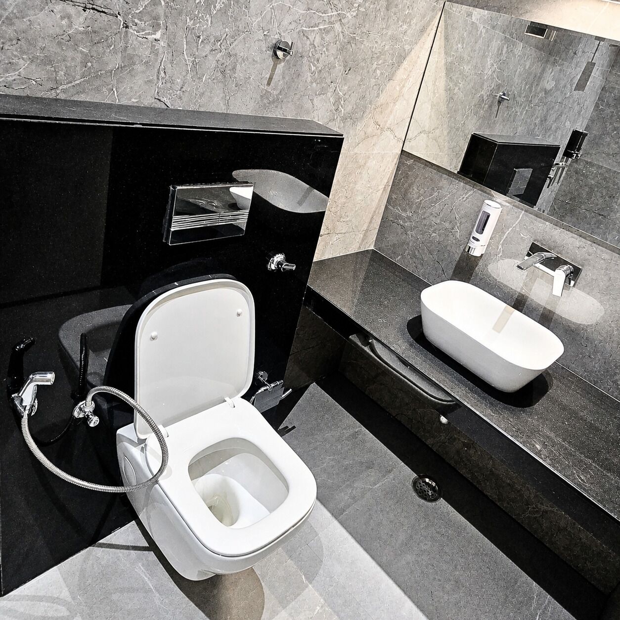 Uma casa de banho moderna com sanita, bidé e lavatório.
