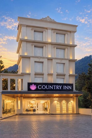 Um edifício de vários andares com uma placa indicando 'Country Inn' na entrada.