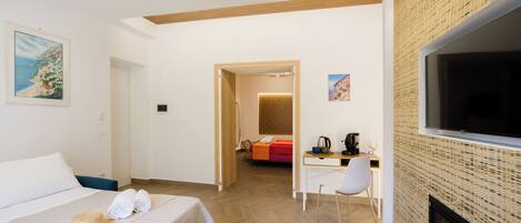 Quarto de hotel com cama, escrivaninha, televisão e lareira.