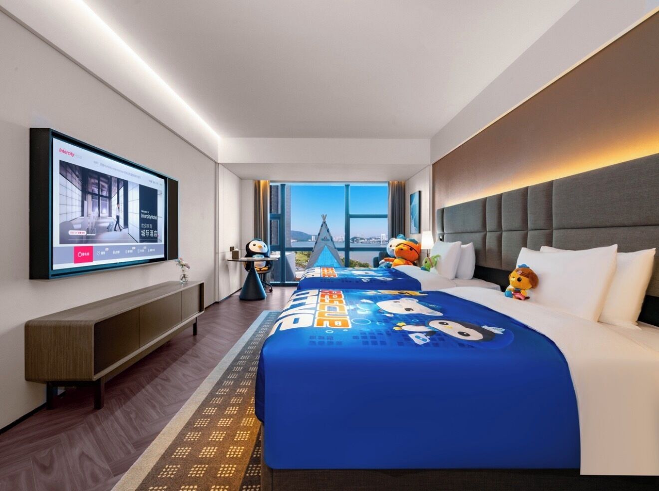Quarto de hotel com uma cama grande, televisão na parede, vista para a cidade e uma janela.