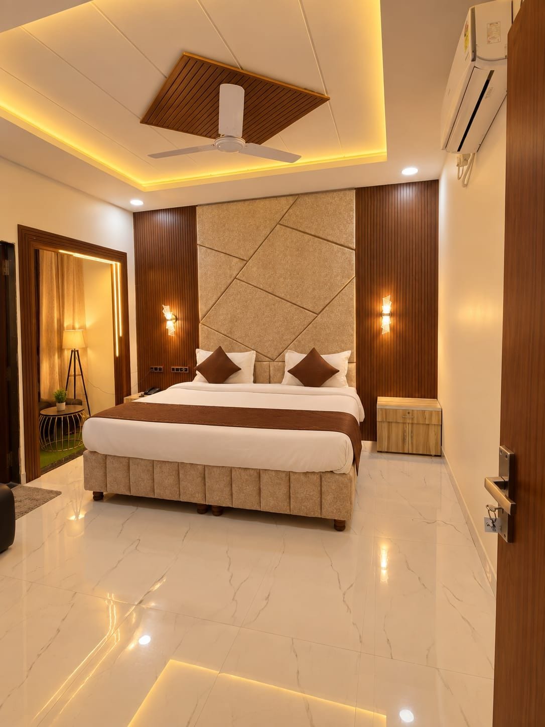 Quarto moderno com uma cama grande, um ventilador de teto e um ar-condicionado fixado na parede.