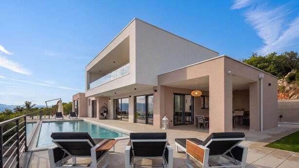 Uma casa moderna de dois andares com piscina, área de estar ao ar livre e vista para as montanhas.