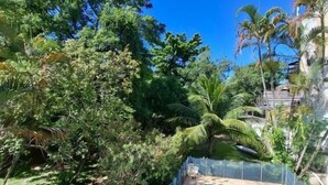 Piscina rodeada por vegetação exuberante e um céu azul límpido.