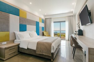 Quarto de hotel moderno com uma cama, escrivaninha, televisão e varanda com vista.