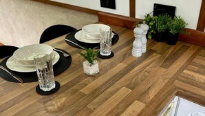 Uma mesa de jantar posta com pratos, copos e uma pequena planta.
