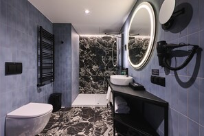 Uma casa de banho moderna com sanita, lavatório e zona de duche.
