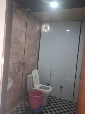 Uma casa de banho pequena com sanita, lavatório e chuveiro.
