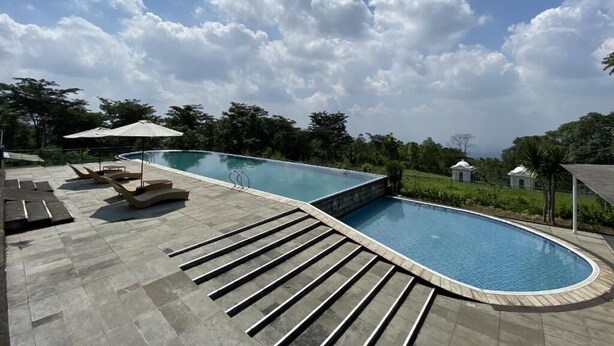Piscina com espreguiçadeiras e um pérgola.