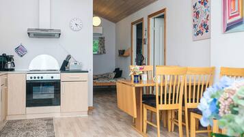 Espaço compacto com cozinha compacta, área de refeições e cama.