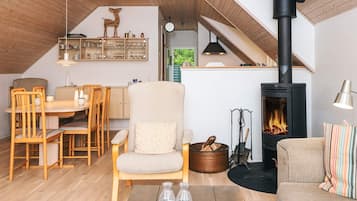 Uma sala de estar aconchegante com lareira, móveis de madeira e um espaço de jantar.