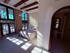 Quarto com uma grande janela, uma cama e vista para o exterior.