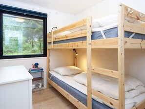Quarto com beliche, escrivaninha e janela.