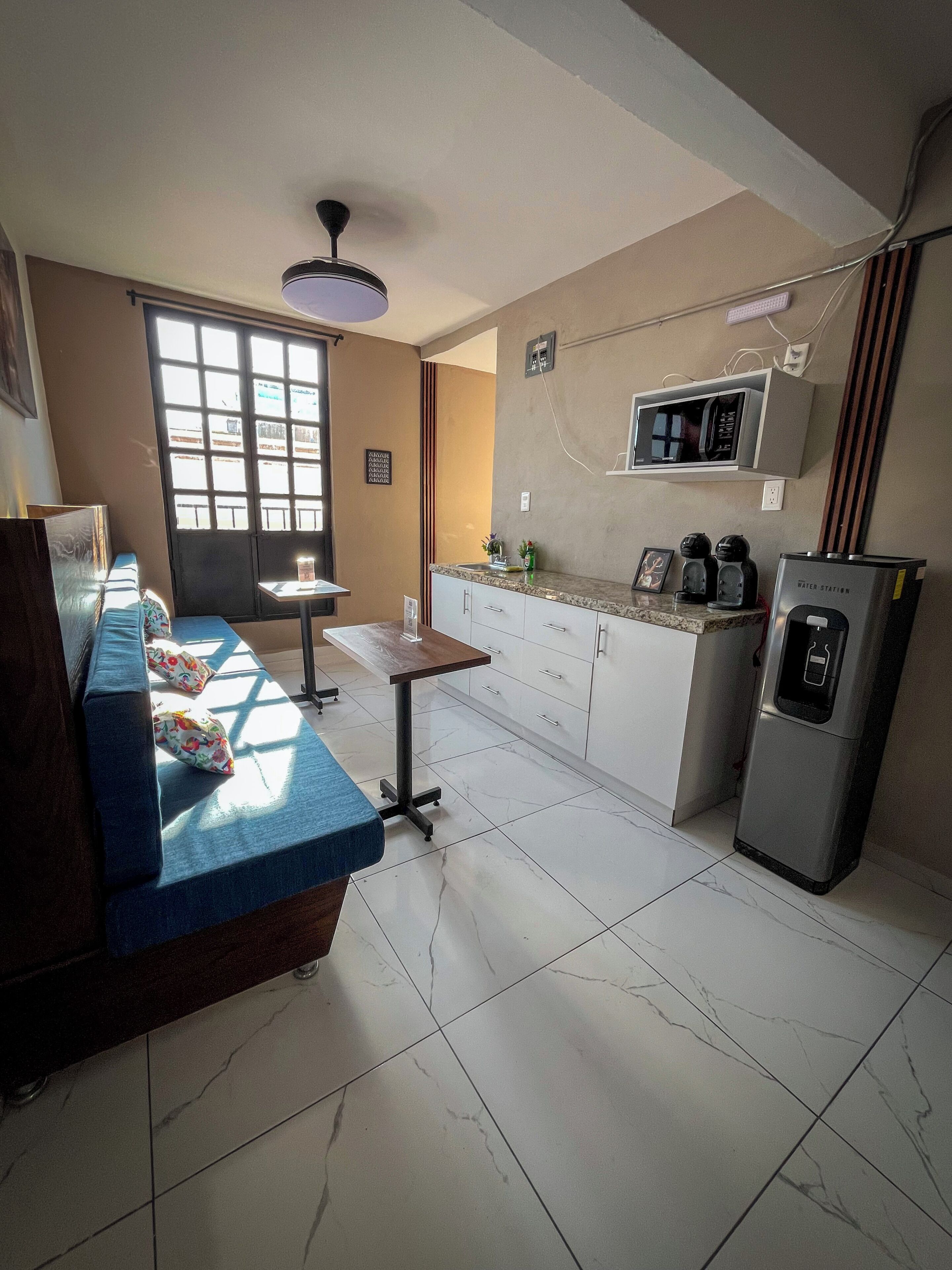 Uma cozinha com área de refeições, ponto de água e ventilador de teto.
