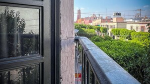 Uma varanda com vista para edifícios e vegetação.